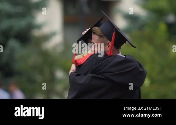 Two friends hugging at graduation ceremony, young people celebrating ...
