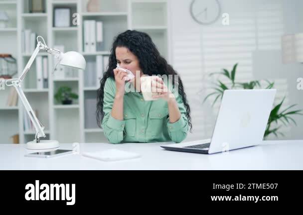 Woman worker sneezes with a runny nose. Employee coughs a cold or flu ...
