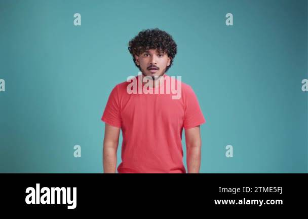 young latin man shows fear fright shock from what he saw on a blue ...