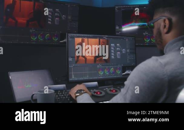 African American colorist makes color grading on control machine in ...