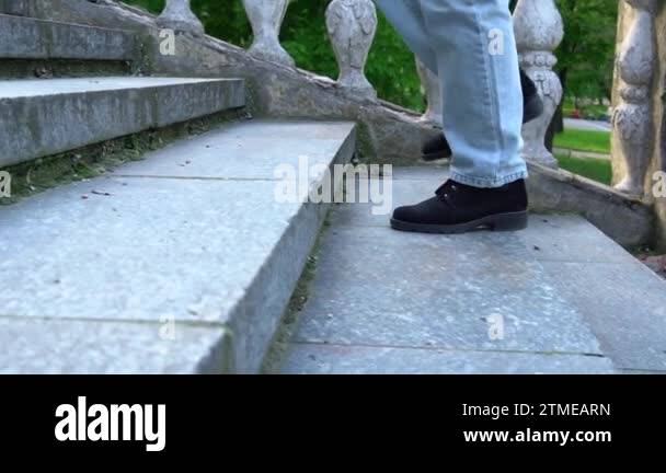 Woman legs in jeans walking on ancient stair back view. Female foot in ...