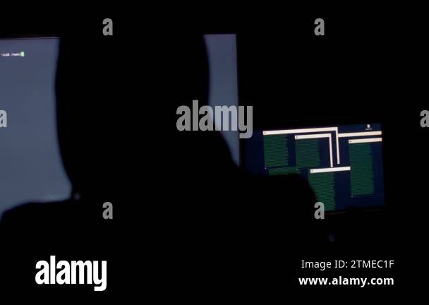 Hacker In Hood Cracking Code Using Computers In Dark Room Stock Video