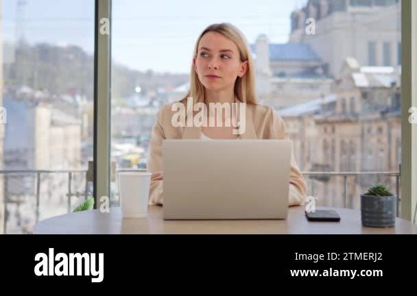 Beautiful blue eyes business woman freelancer working on laptop in cafe ...