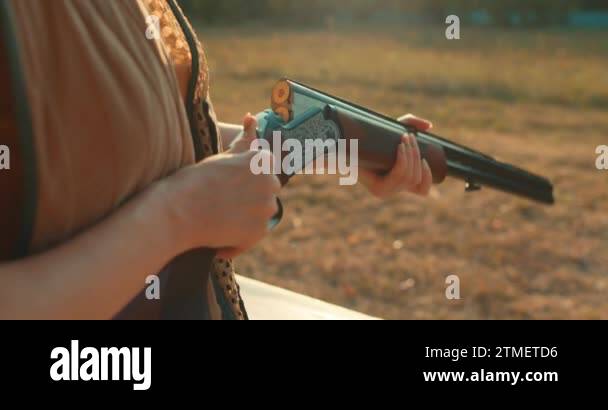 woman holding and reloading the rifle gun cropped video. girl loads ...