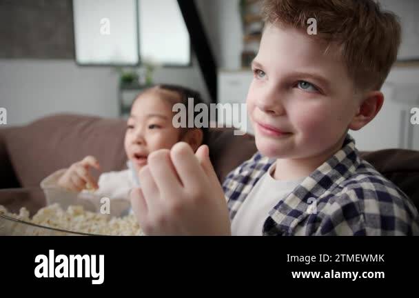 Multiracial Kids Eat Popcorn Sitting On Sofa Close Up. Little girl and ...
