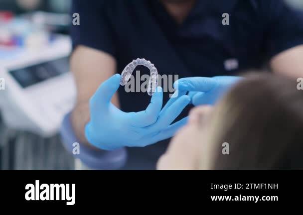 Orthodontist in rubber gloves holding transparent aligners for ...