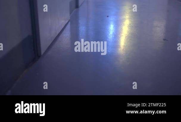 Reflection of flashing light in the floor surface of a dark room. Blue ...