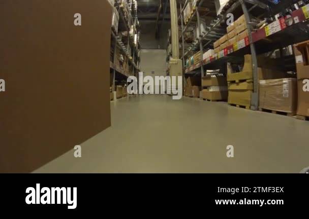 POV Shopping cart with large cardboard box moving between the rows of ...