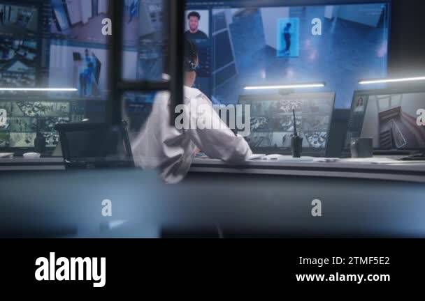 Female officer in headset monitors security cameras with AI facial ...
