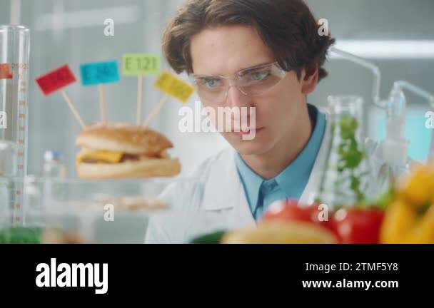 Young male researcher examines a sample of burger labeled E142, E240 ...