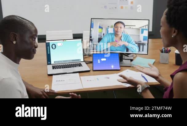 Diverse business people having video call and using laptop with digital ...