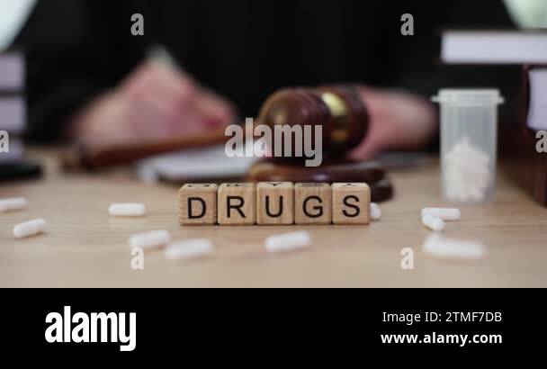 Word Drugs made of wooden cubes against female judge taking notes ...
