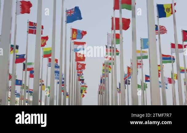 bottom view footage of flags of world waving on blue sky background ...