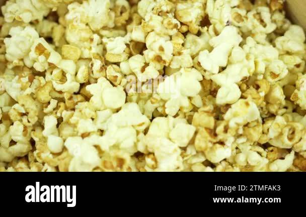 Freshly cooked popcorn with butter rotating. Popcorn background. Cinema ...