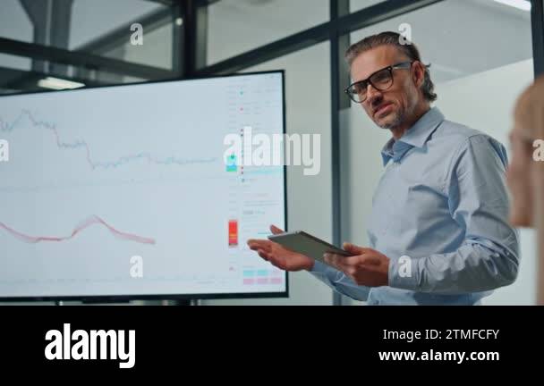 Charismatic businessman showing tv screen in office interior close up ...