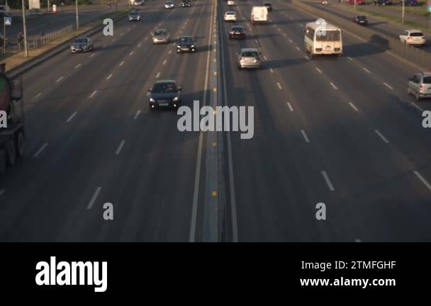 Traffic on an eight-lane asphalt road of cars, trucks, buses. Loaded ...