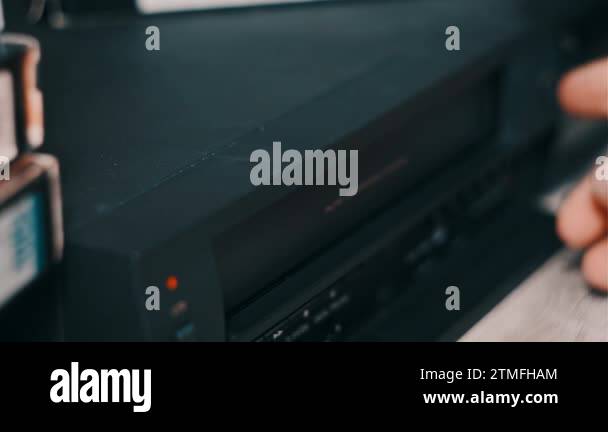 Male hand pulls out VHS from a vintage videotape recorder. Eject VHS ...