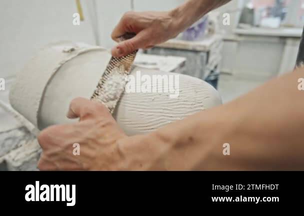 Unrecognizable craftsman removing extra layer of material of artificial ...