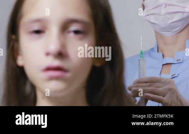 little girl is afraid of the doctor with a syringe. baby cries afraid ...