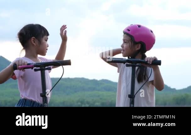 Two cute little girls smiling and posing together in summer garden ...