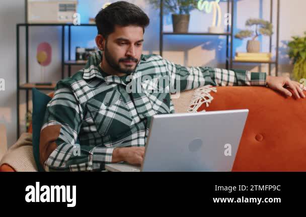 Displeased indian man use laptop notebook typing browsing working ...