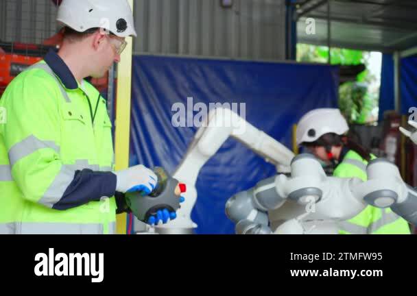 Two young engineer checking and maintenance machine robot arms ...