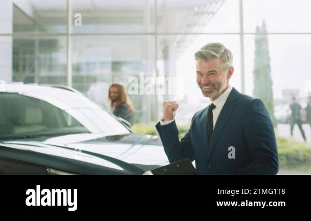 A successful businessman in a car dealership selling vehicles. Seller ...