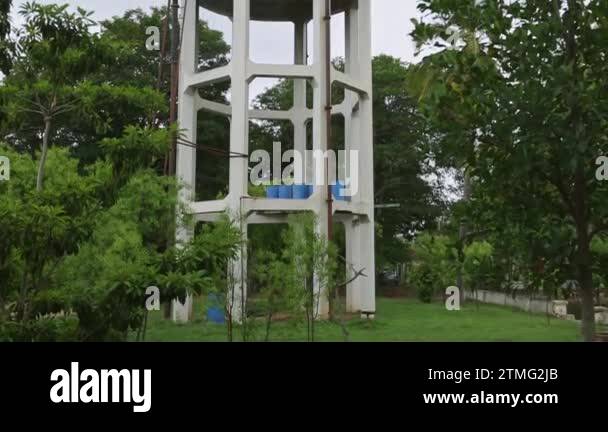 A low-angle view of a water tower in a small Indian village. old water ...