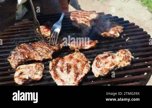 Grill master chef checks the doneness of the meat. Grilled juicy meat ...