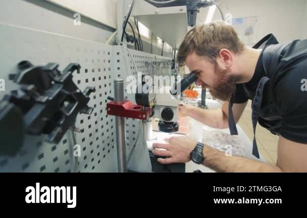 Diagnostics of diesel injectors under a microscope. The master examines ...