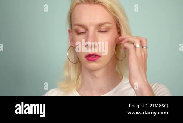 Androgyny. Transgender guy with makeup posing on background. Masculine ...