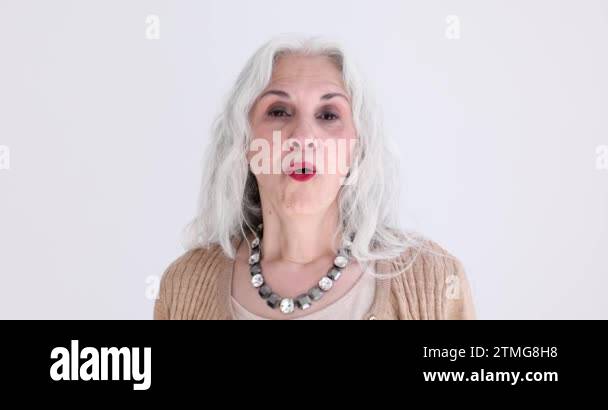 Emotional mature woman shows surprised facial expression staring in ...