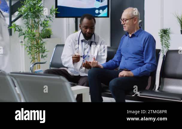 Specialist doing medical test with diabetic man in hospital waiting ...
