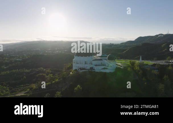 Epic arial above Griffith Observatory domes and green lawn observation ...