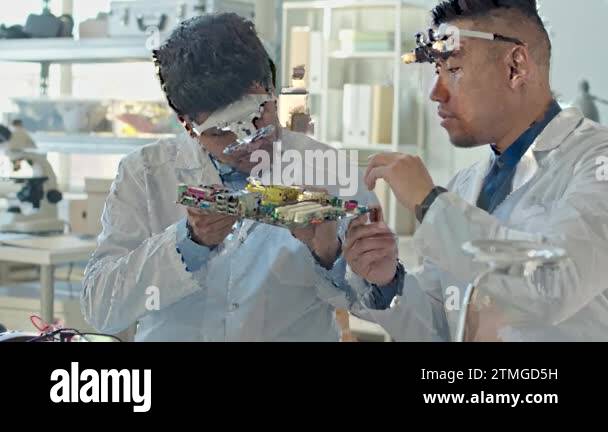 Medium slowmo of two male engineers in professional magnifying eyewear ...