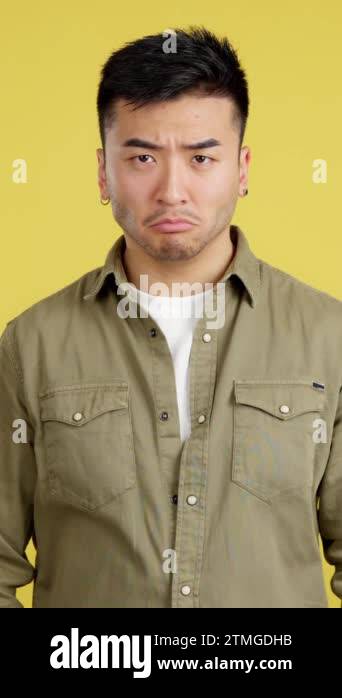 Chinese man crossing the arms with an angry expression while looking at ...