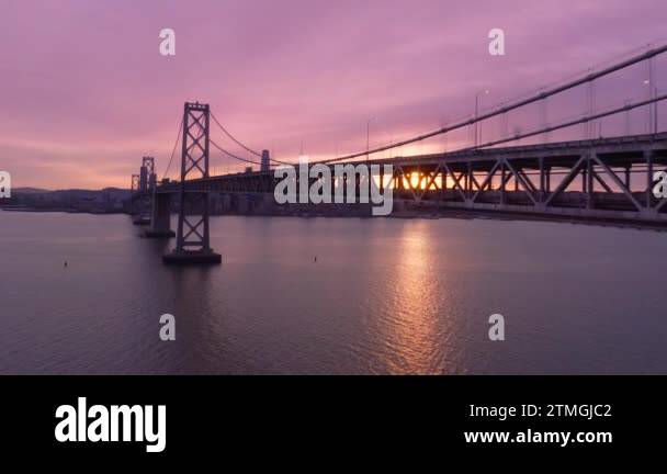 Drone flying above water surface along Bay Bridge construction with ...