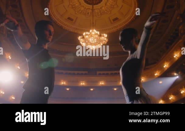 Couple of ballet dancers practice choreography moves on theater stage ...