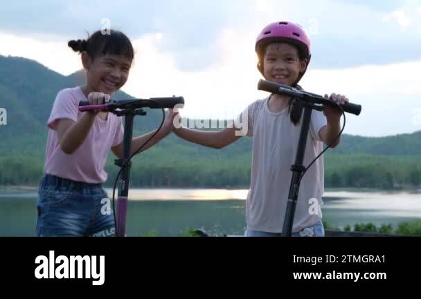 Two cute little girls smiling and posing together in summer garden ...