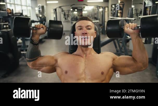 Muscular bodybuilder man lifting heavy weights black dumbbells. One ...