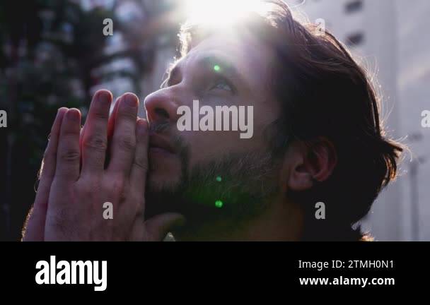 Faithful young man looking up at sky in prayer asking for God's help ...