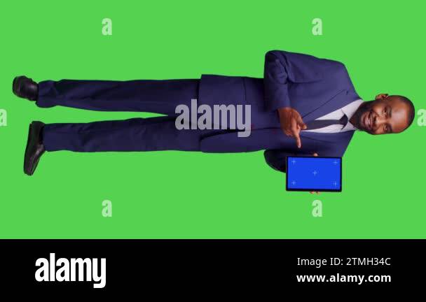 Vertical video: Front view of smiling businessman showing tablet with ...