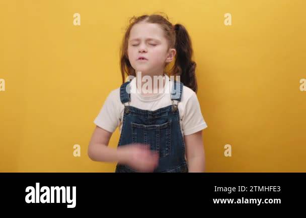 Portrait of little girl kid wearing casual clothes smelling something ...