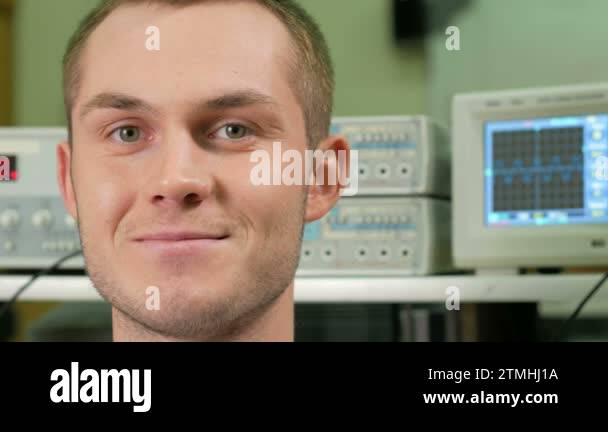 Young attractive man in the room with electrical equipment smiling at ...