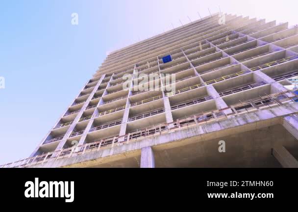 Large and tall unfinished house against blue sky. Bottom view, camera ...