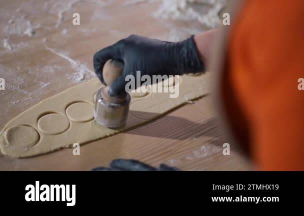 High angle view close-up unrecognizable woman cutting round pieces with ...