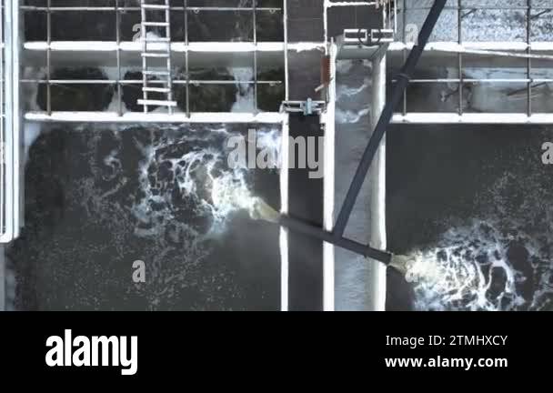 Pouring sewage water into pools from pipe at treatment plant in winter ...