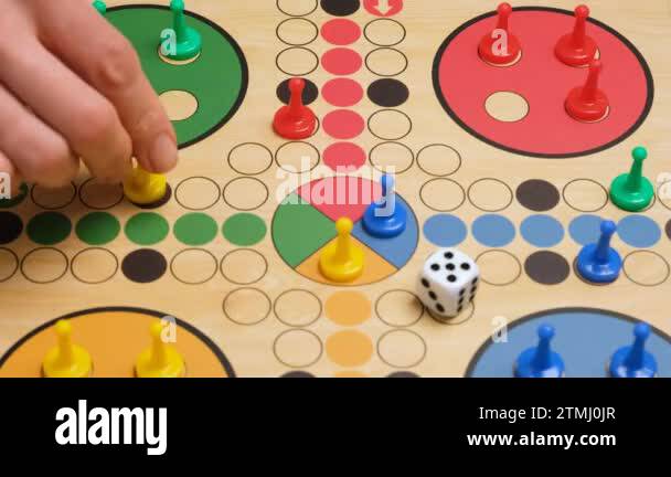 People play Ludo or Pachisi board game on beautiful wooden play board ...