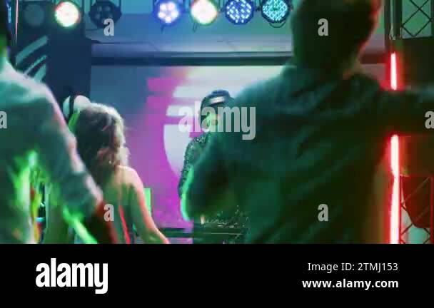 Funky woman putting music on stage, partying at nightclub with group of ...