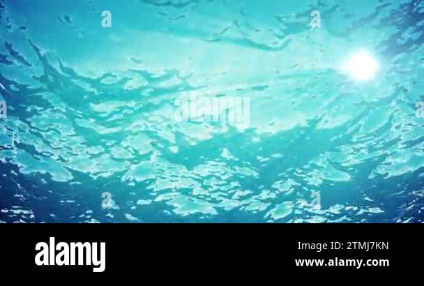 High quality animation of ocean waves from underwater with floating plankton. Light rays shining ...